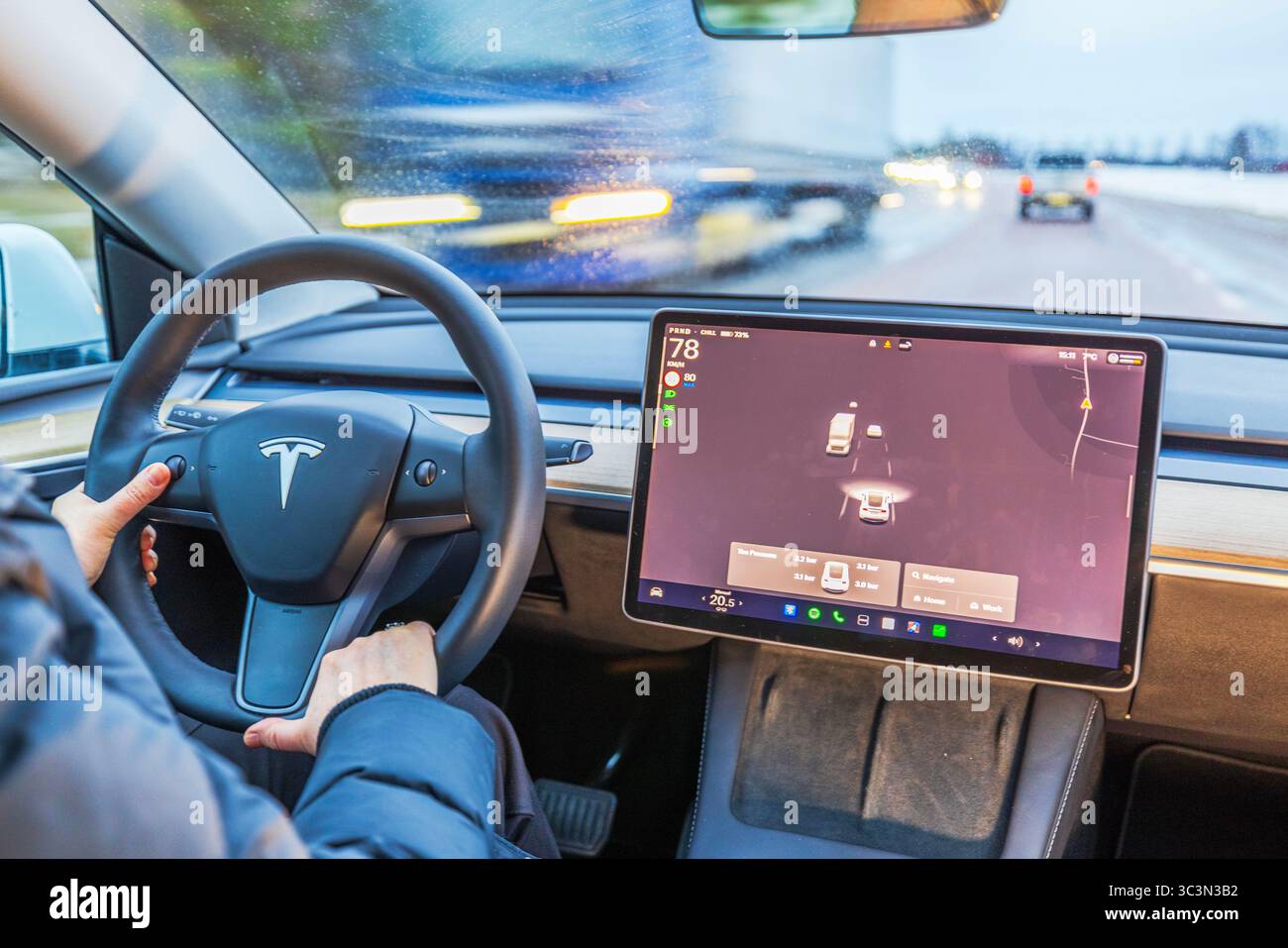 Tesla Model Y interior with autopilot screen while driving on snowy ...