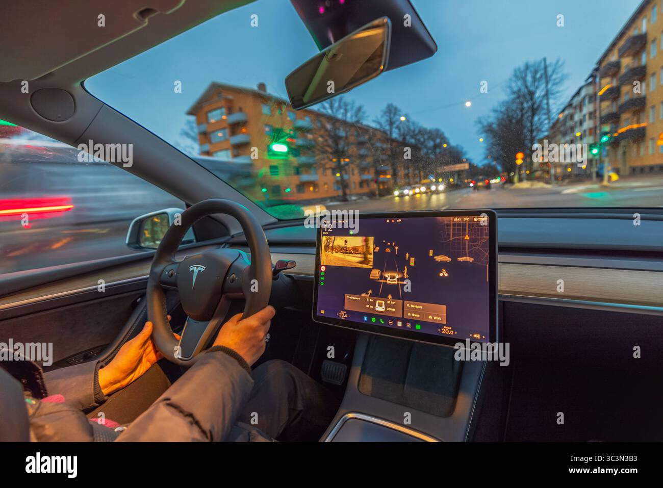 Woman drives Tesla Model Y through city street with autopilot screen in ...