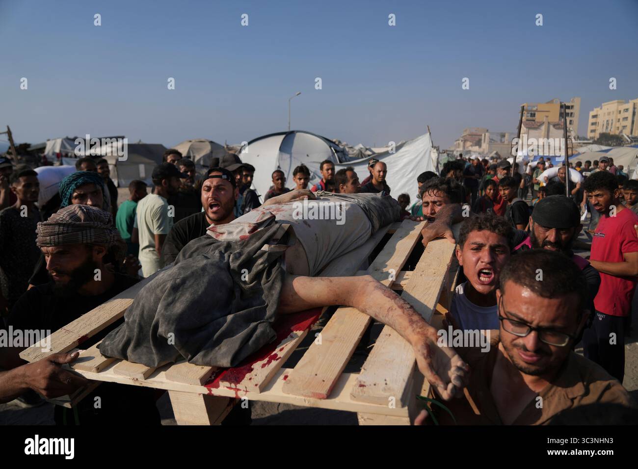 Palestinians carry the body of a man who was killed while trying to ...