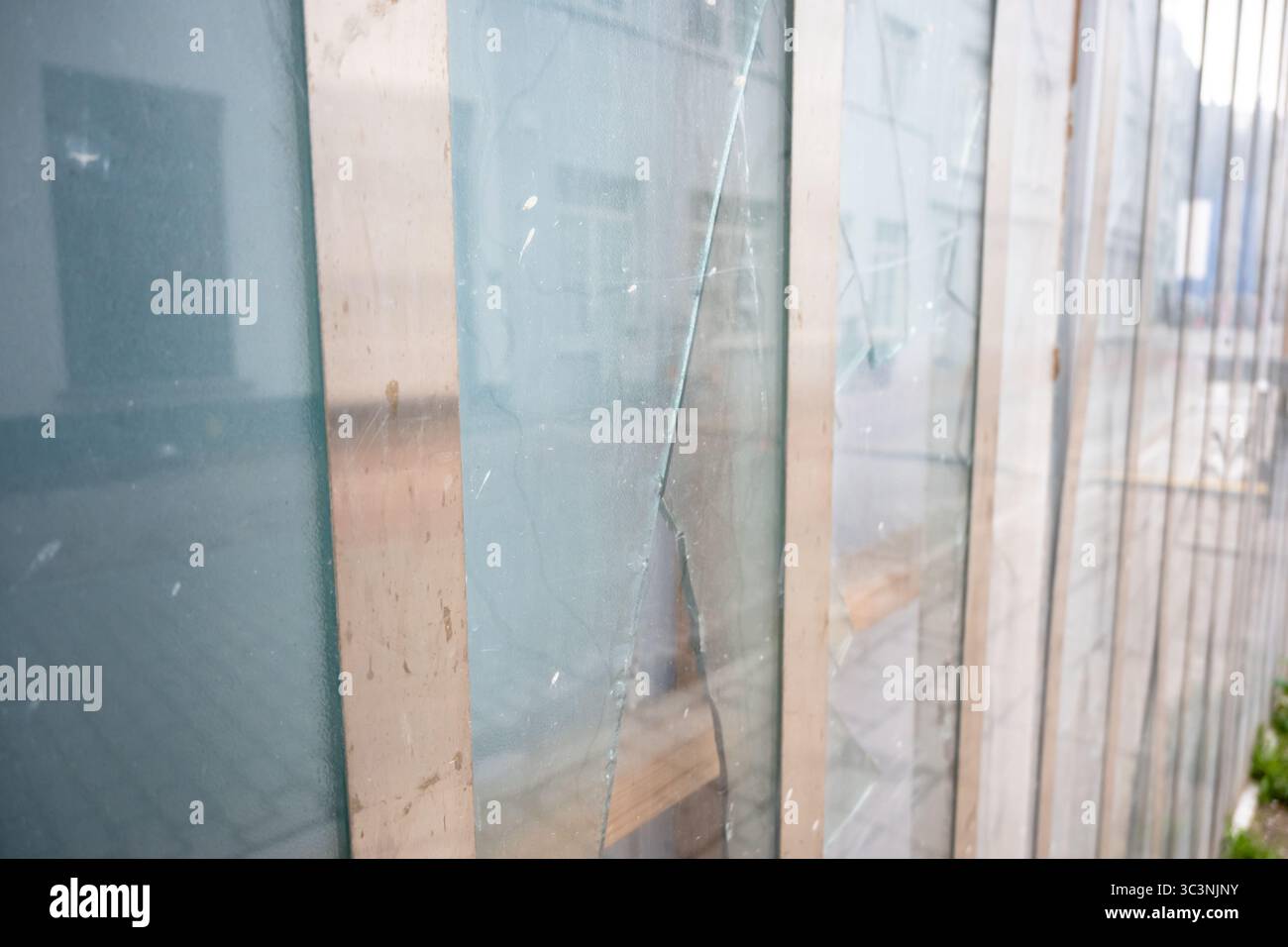 Old broken glass with big and little cracks in close building. Dirty ...