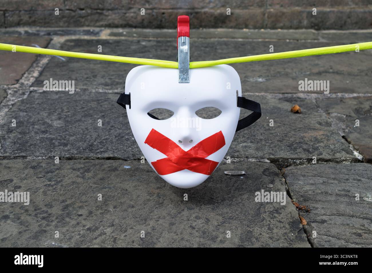 Bristol, UK. 26th Jul, 2025. A face mask with red tape placed over its ...