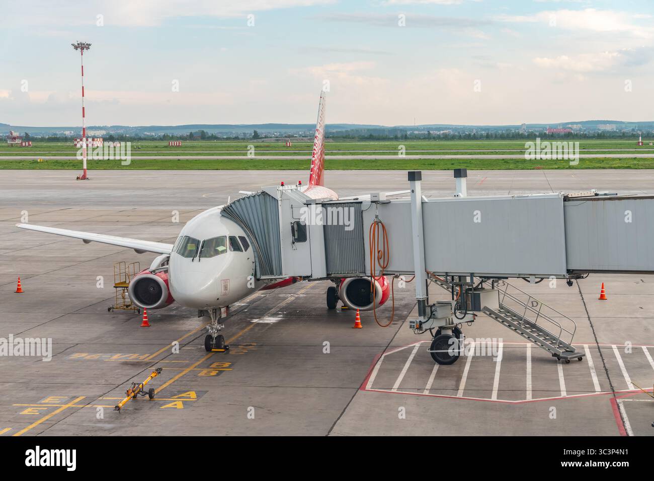 Passenger plane on the airfield connected to walkway.The gate sleeve is ...