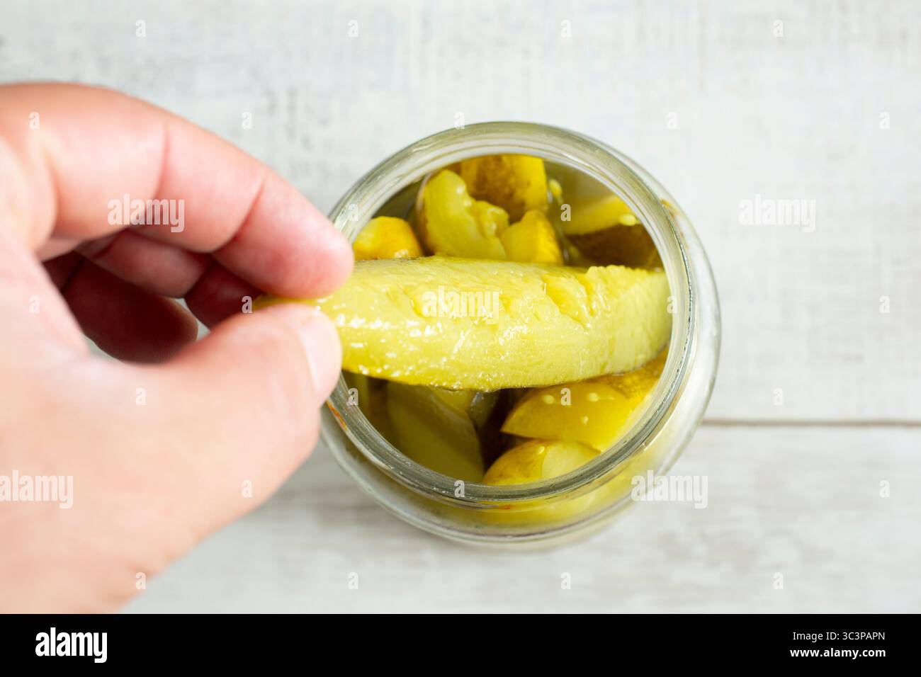 A top down view of a hand pulling out a pickle from a jar Stock Photo ...