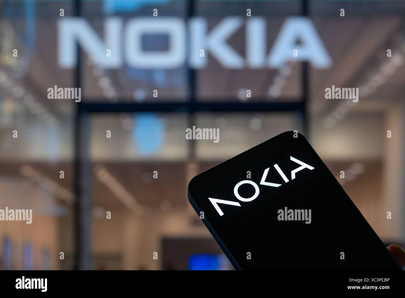 The Nokia is being displayed on a mobile phone with Nokia store seen in ...