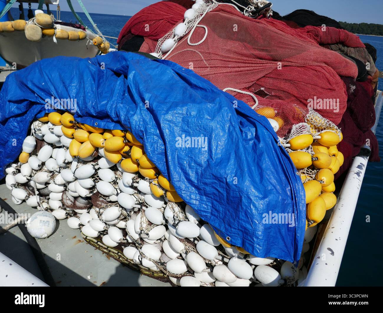 Commercial fishing boat with net and floats covered in tarp Stock Photo ...