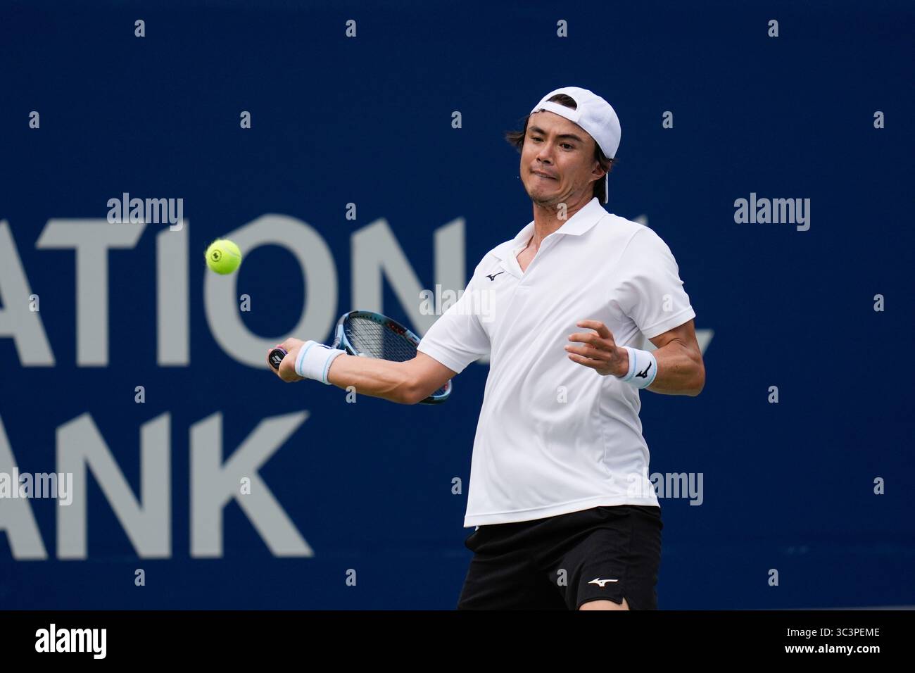 Taro Daniel of Japan plays a forehand against Dan Martin of Canada ...