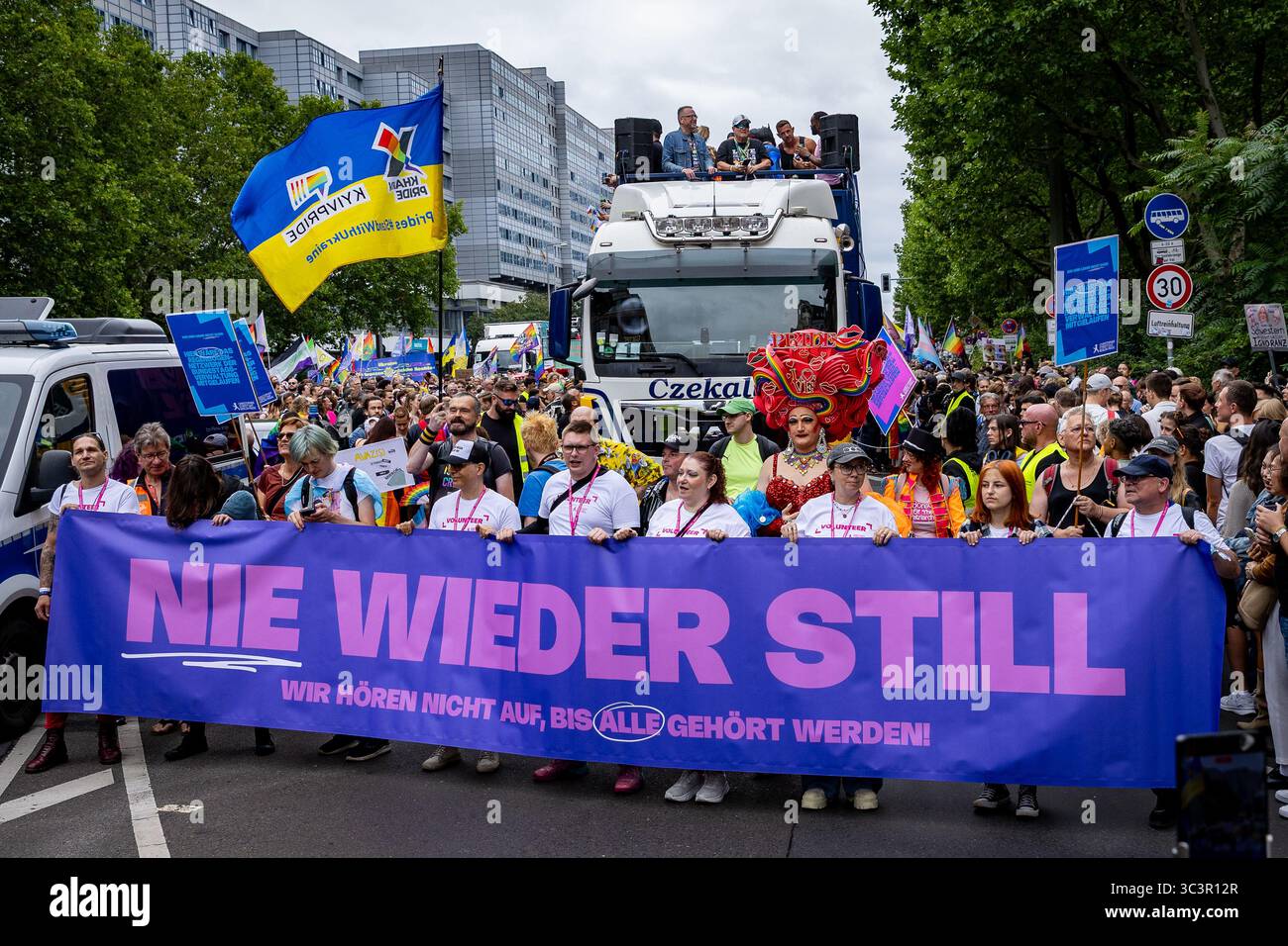Participants march with a banner during the parade. Hundreds of ...