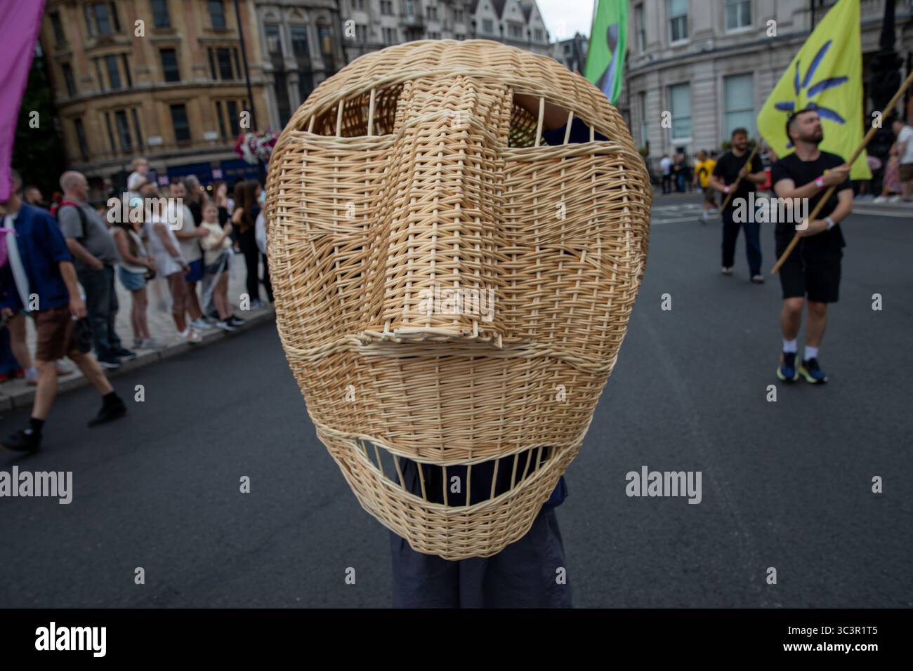 An artist wears a giant woven mask during a procession. For the ...