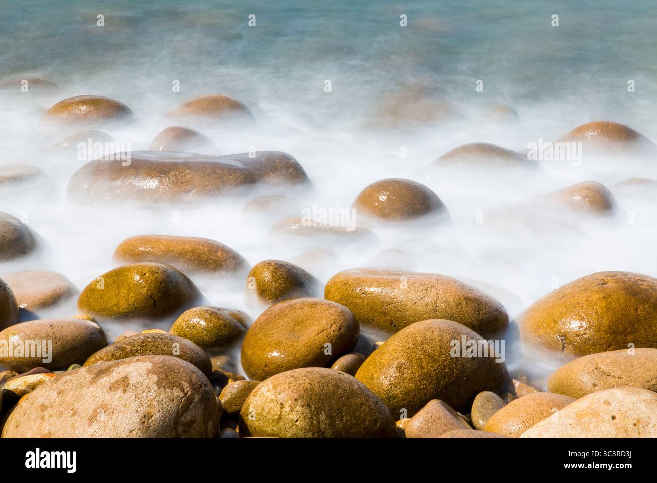 Pebbles washed up by waves on the beach Stock Photo - Alamy