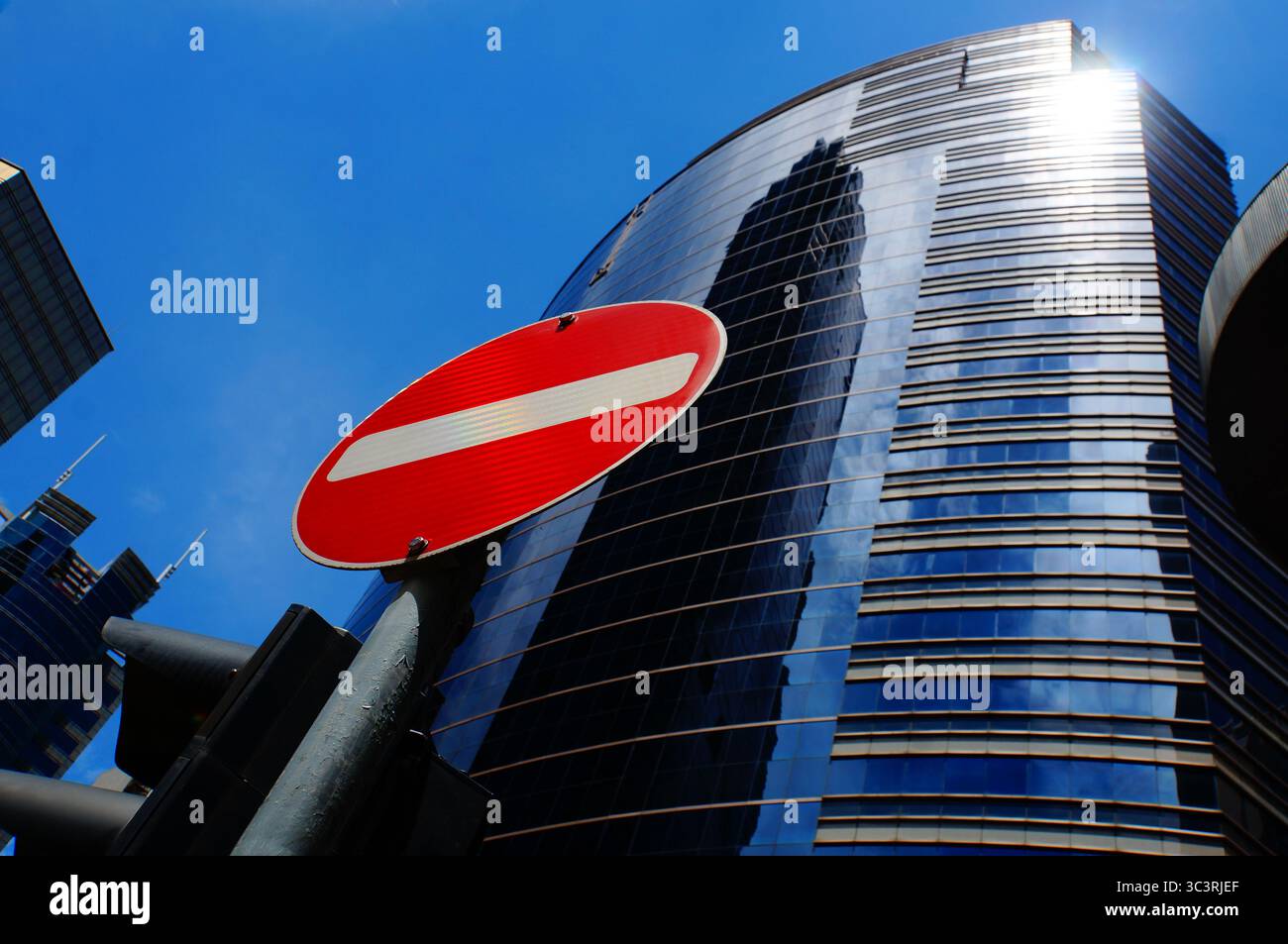 Stop sign in front of a towering building Stock Photo - Alamy