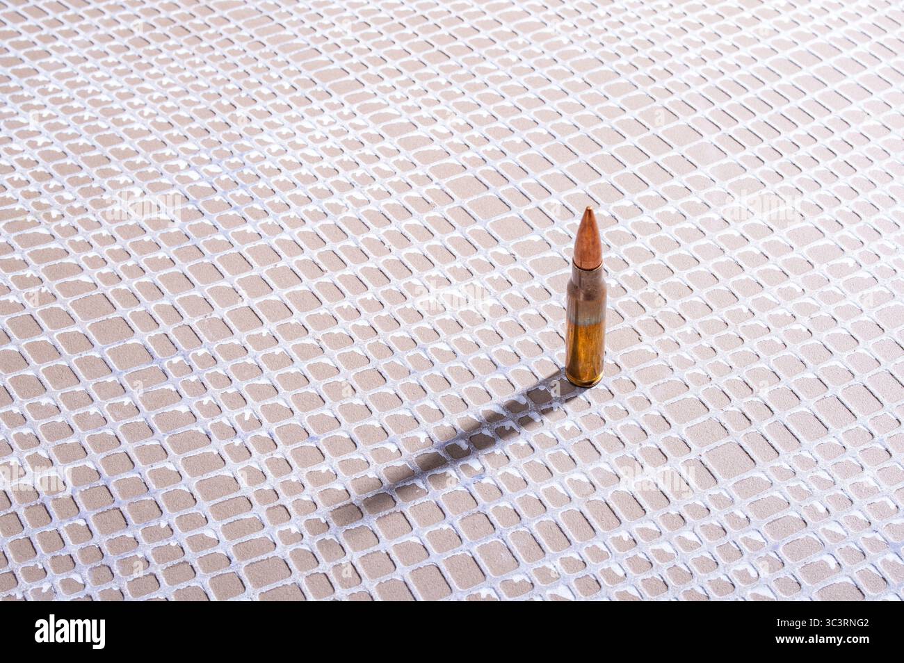 A bullet with a gold tip is sitting on a white background. The bullet ...