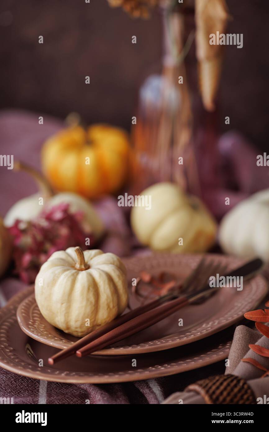 Cozy fall dinner setting with rustic pumpkins and soft pink plates ...