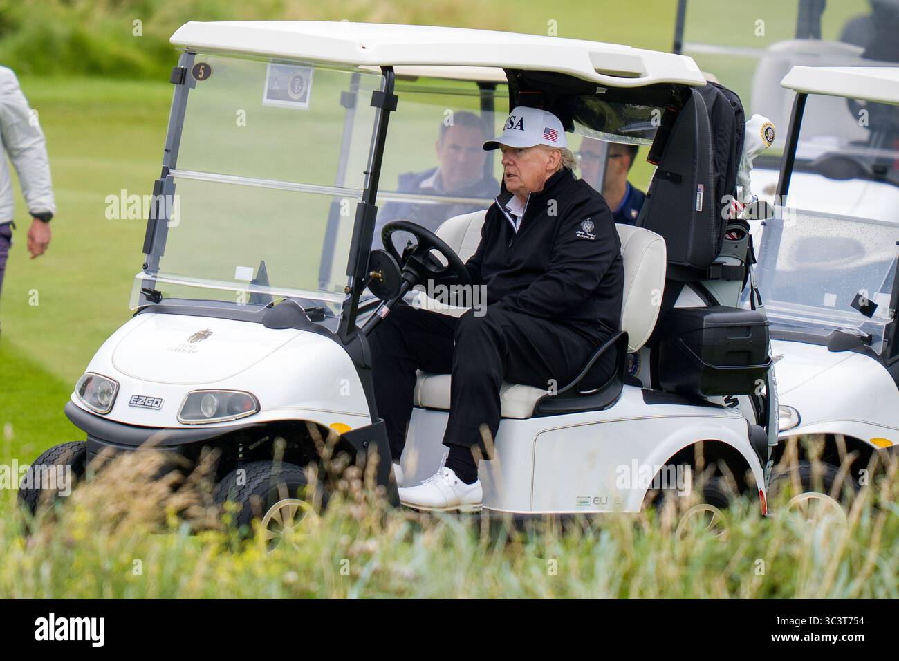US President Donald Trump steers a golf cart at his Trump Turnberry ...