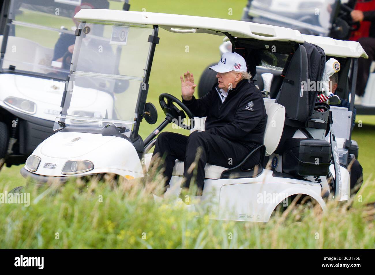US President Donald Trump steers a golf cart at his Trump Turnberry ...