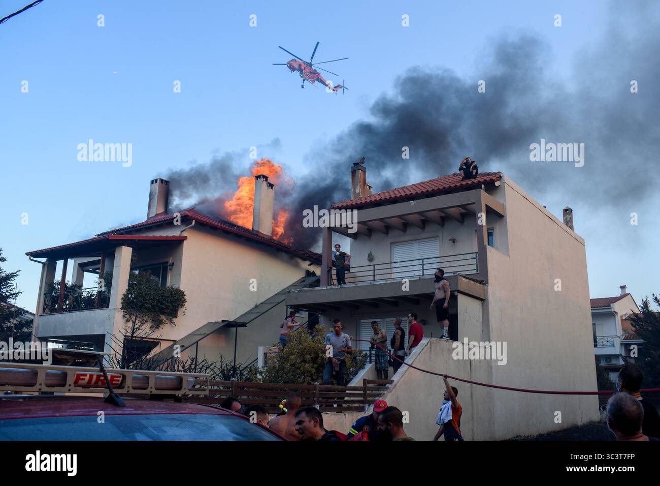 Athens, Greece, 26 July 2025. A firefighting helicopter and volunteers ...