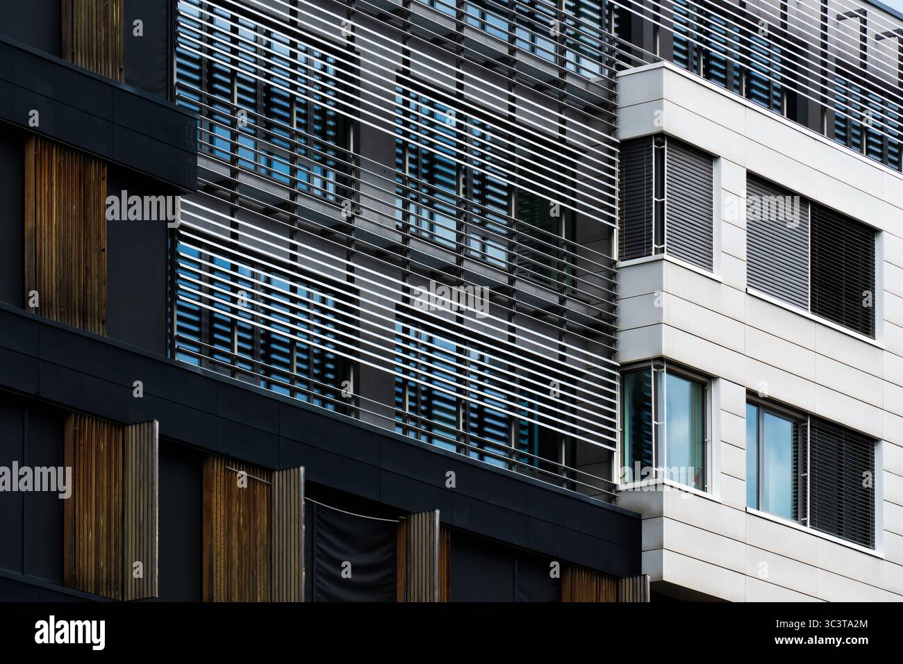 Modern residential facade with mixed materials and layered shading ...