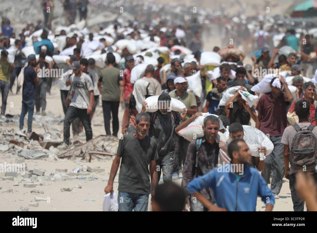 People make their way along al-Rashid street in western Jabalia towards ...