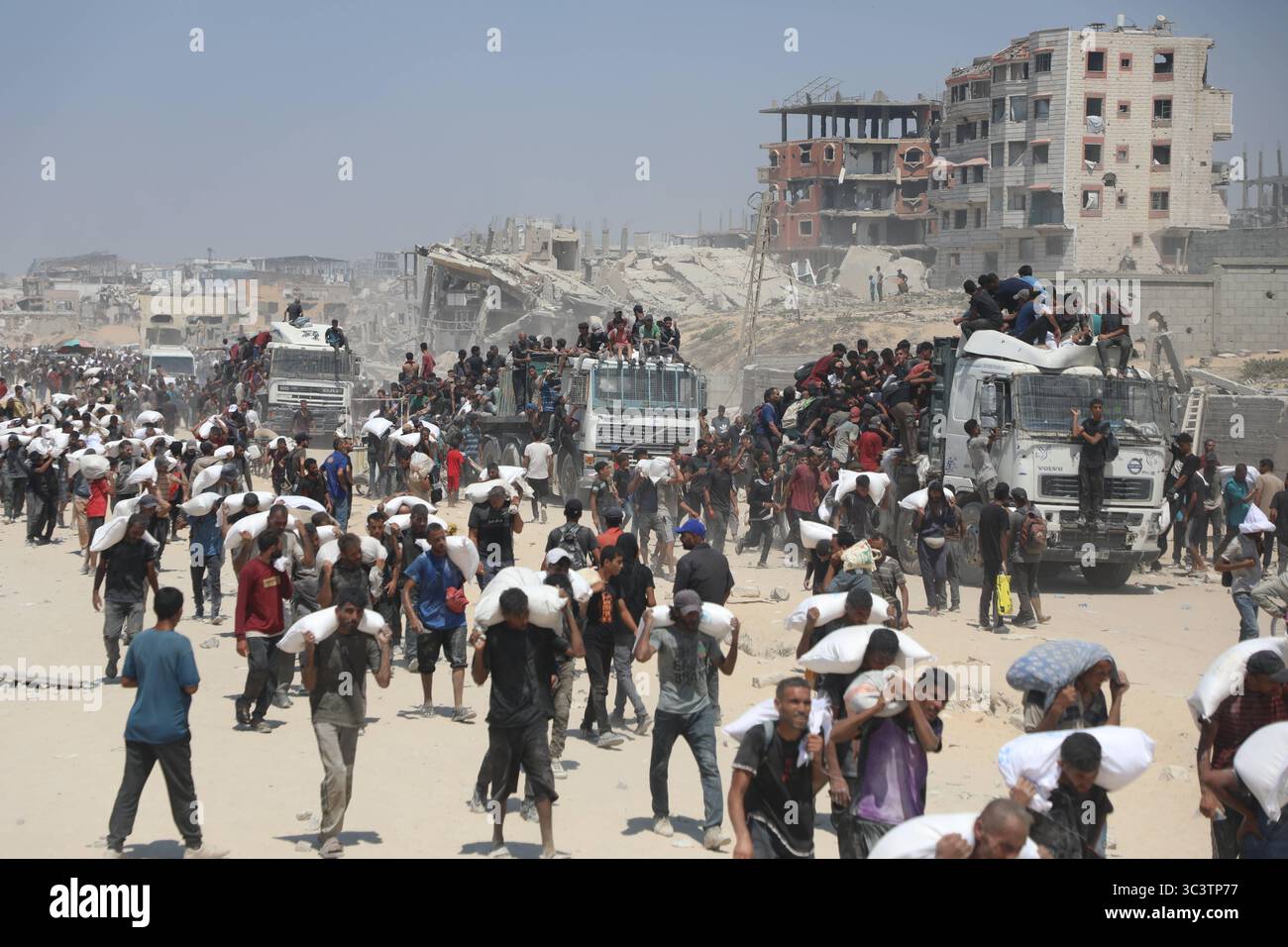 People make their way along al-Rashid street in western Jabalia towards ...