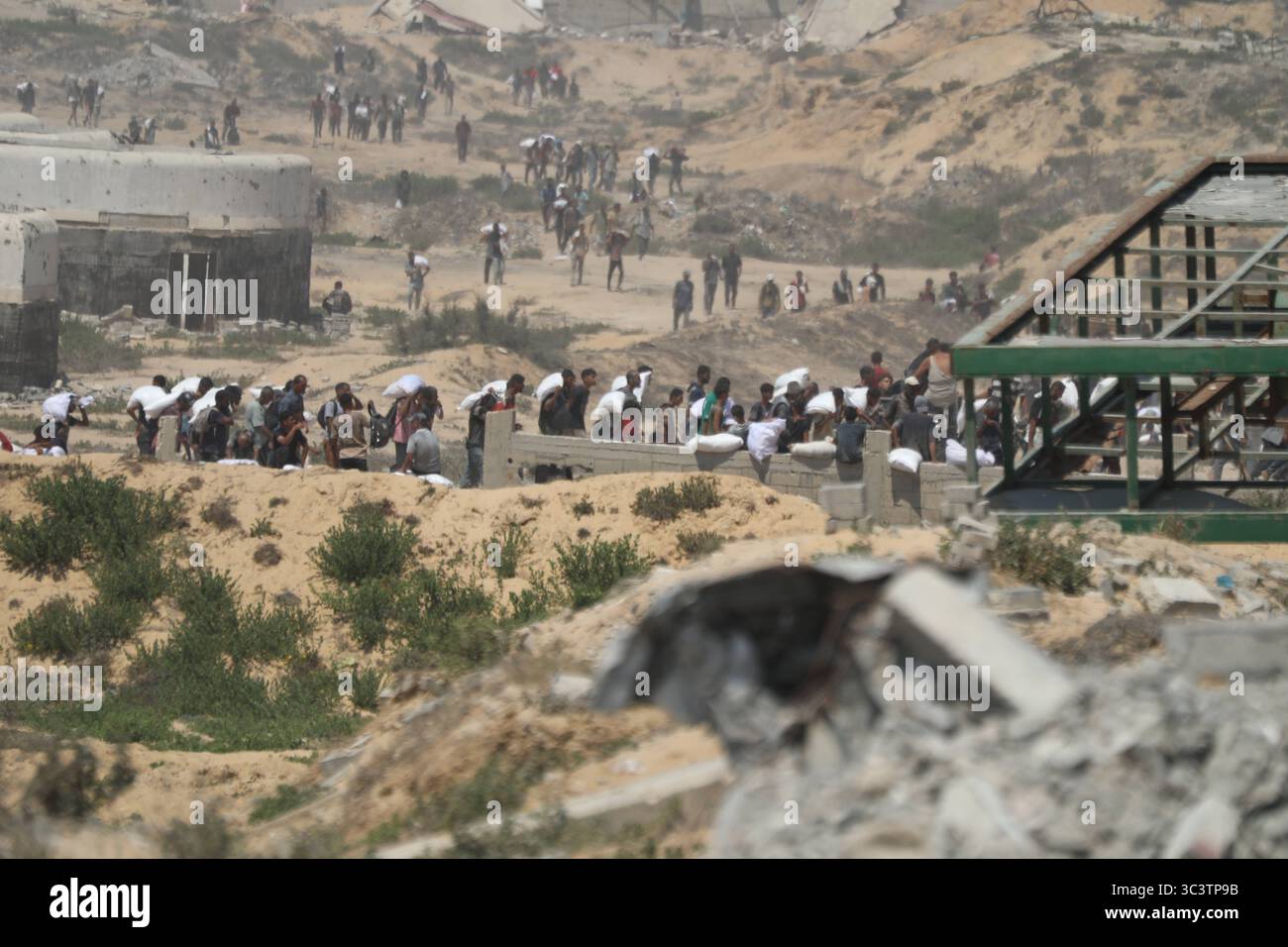 People make their way along al-Rashid street in western Jabalia towards ...