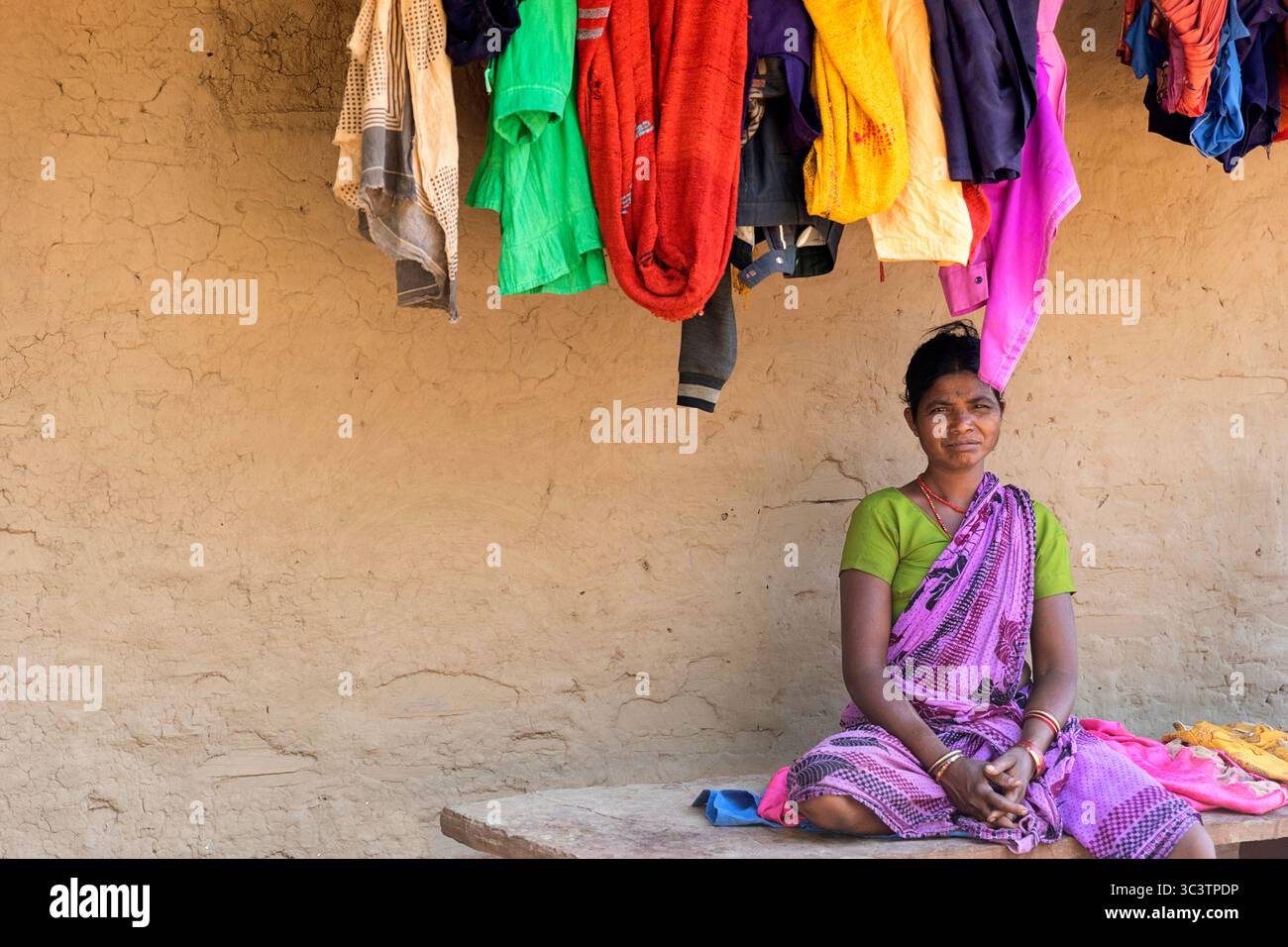 Woman sitting in front of a colourful traditional house of a bison horn ...