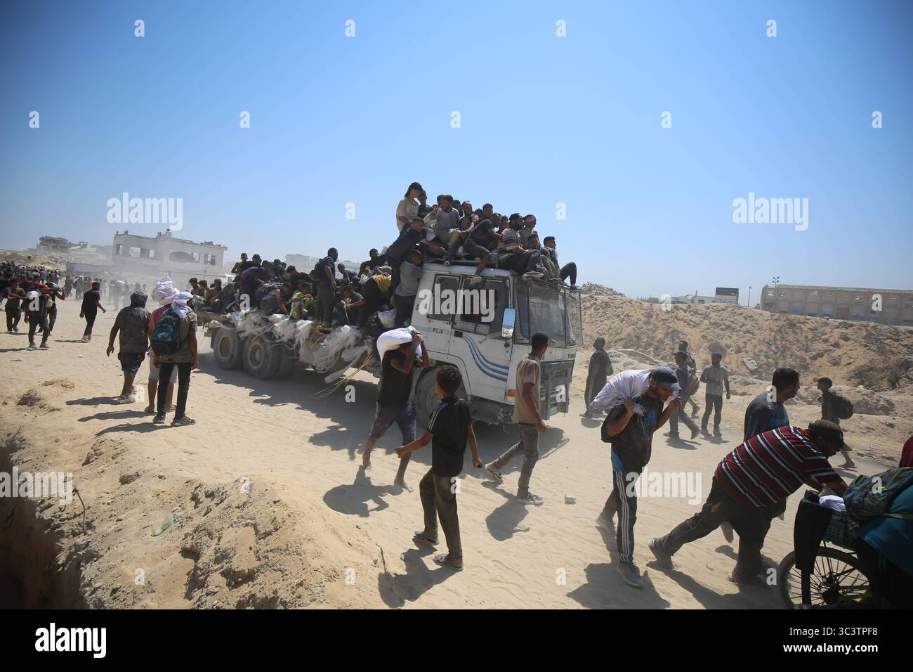 People make their way along al-Rashid street in western Jabalia towards ...