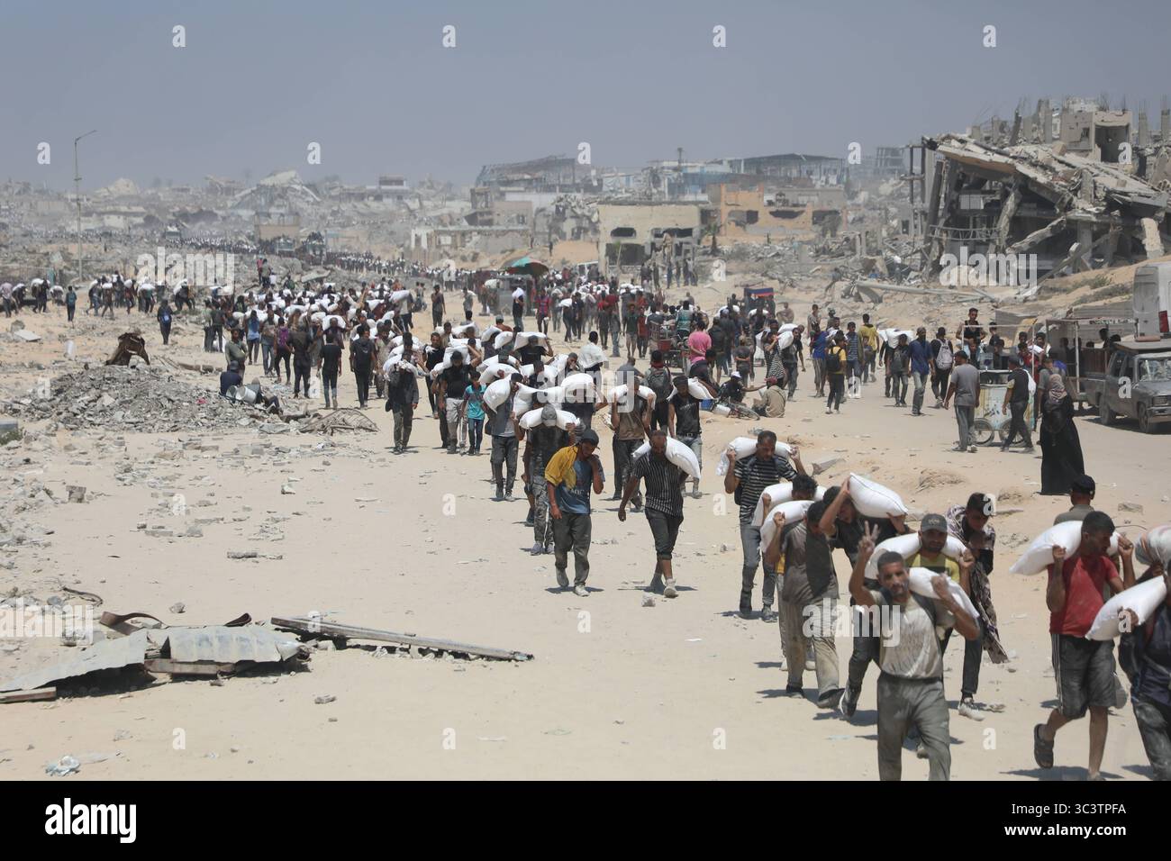 People make their way along al-Rashid street in western Jabalia towards ...