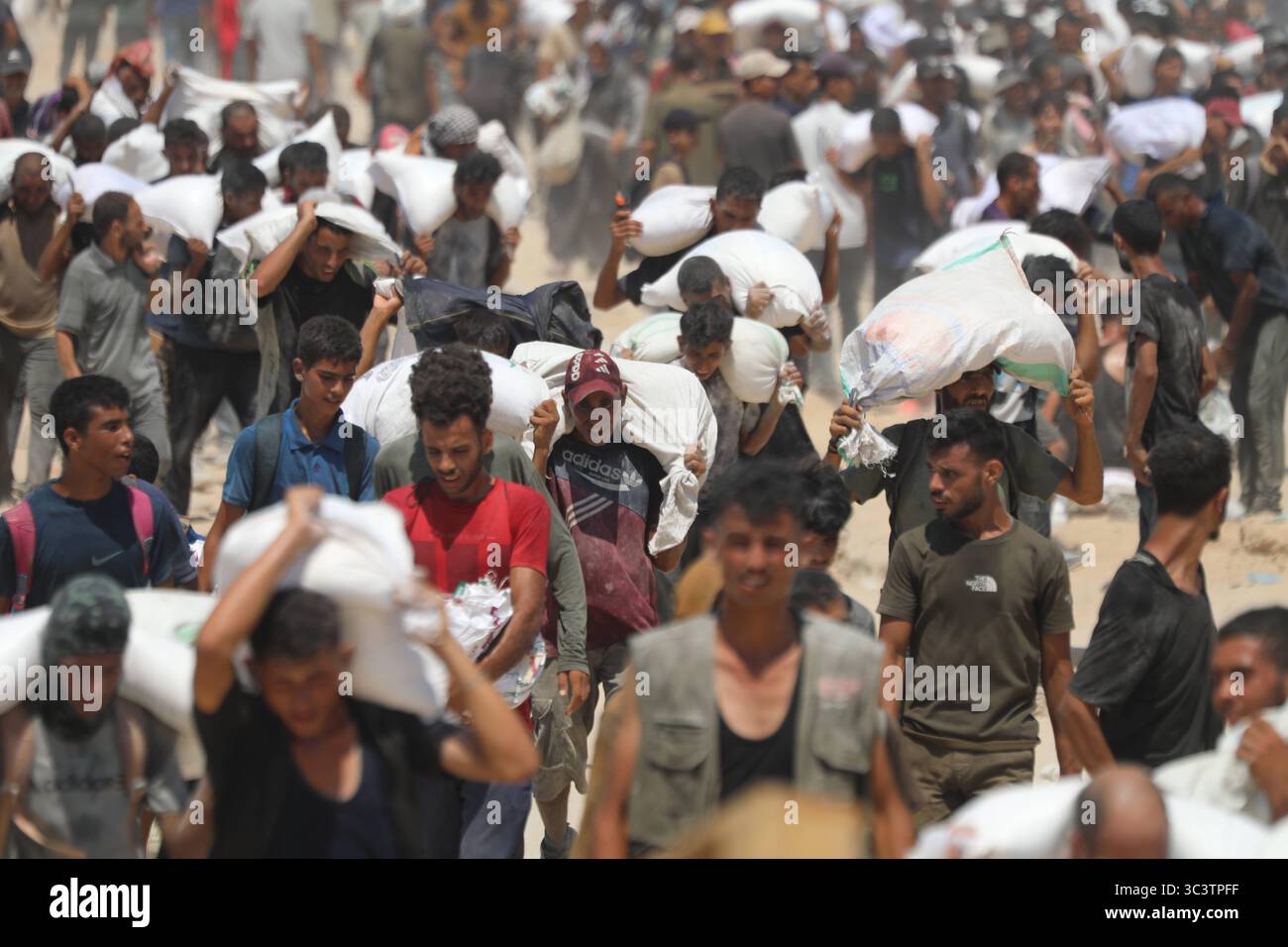 People make their way along al-Rashid street in western Jabalia towards ...