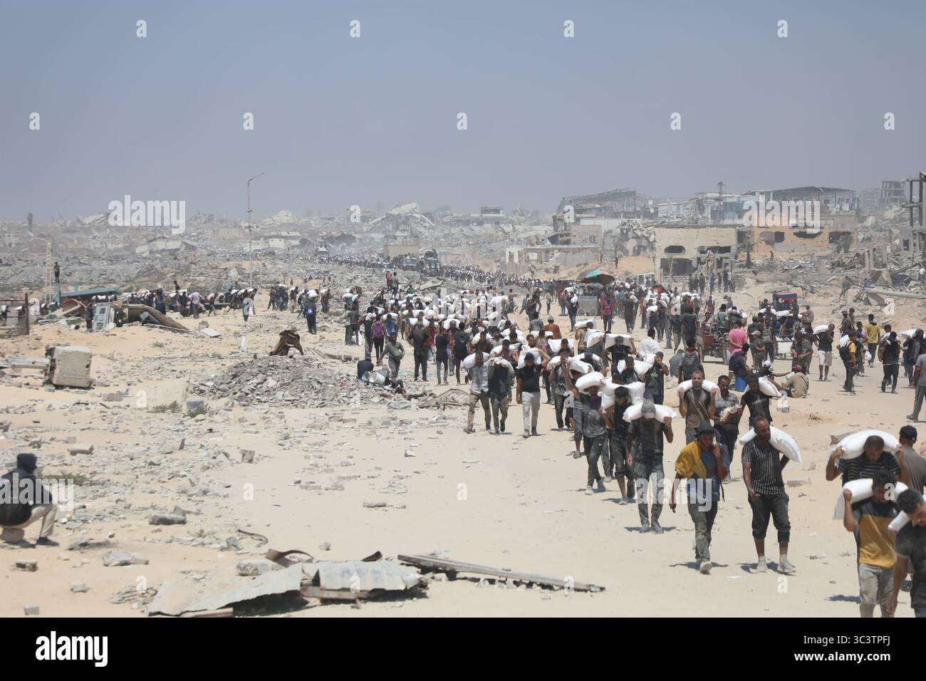 People make their way along al-Rashid street in western Jabalia towards ...