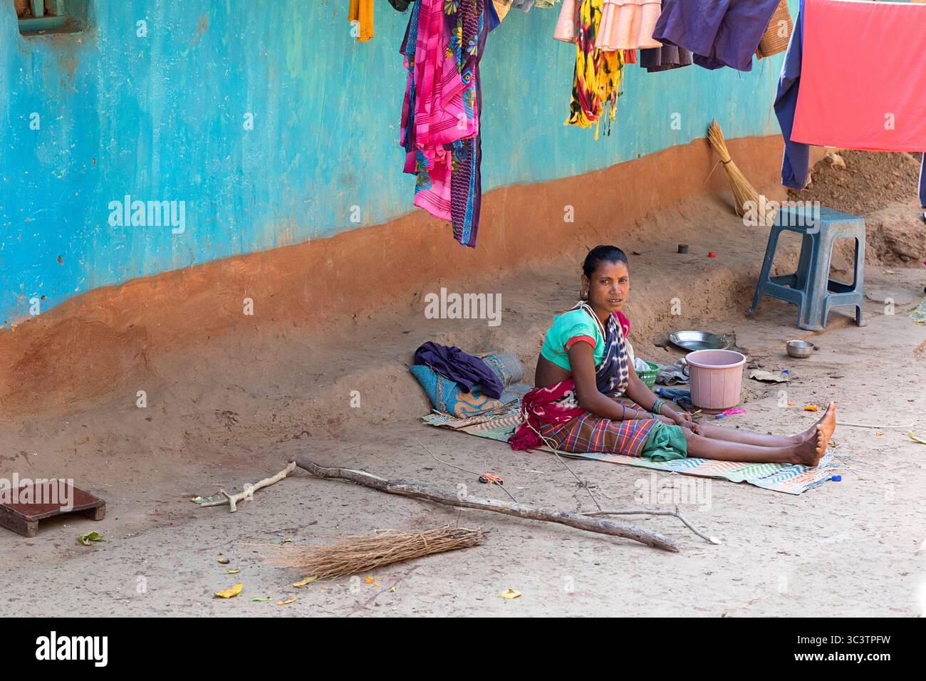 Woman sitting in front of a colourful traditional house of a bison horn ...