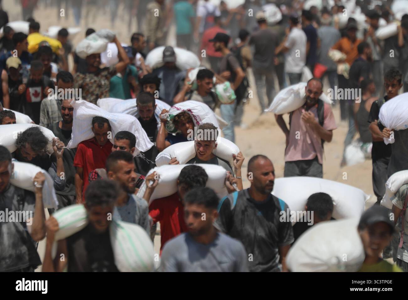 People make their way along al-Rashid street in western Jabalia towards ...