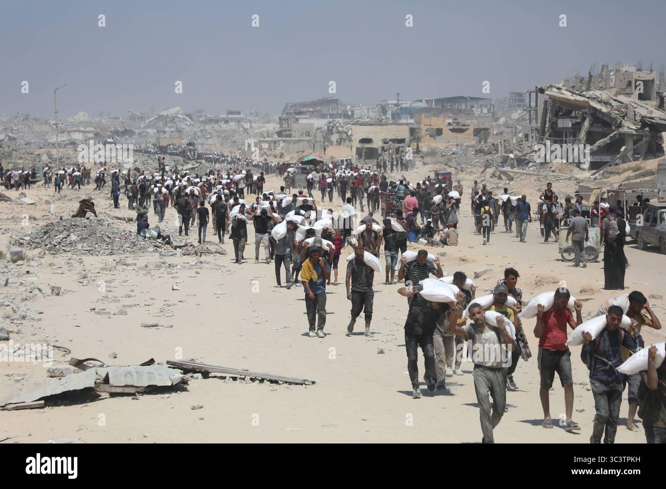People make their way along al-Rashid street in western Jabalia towards ...
