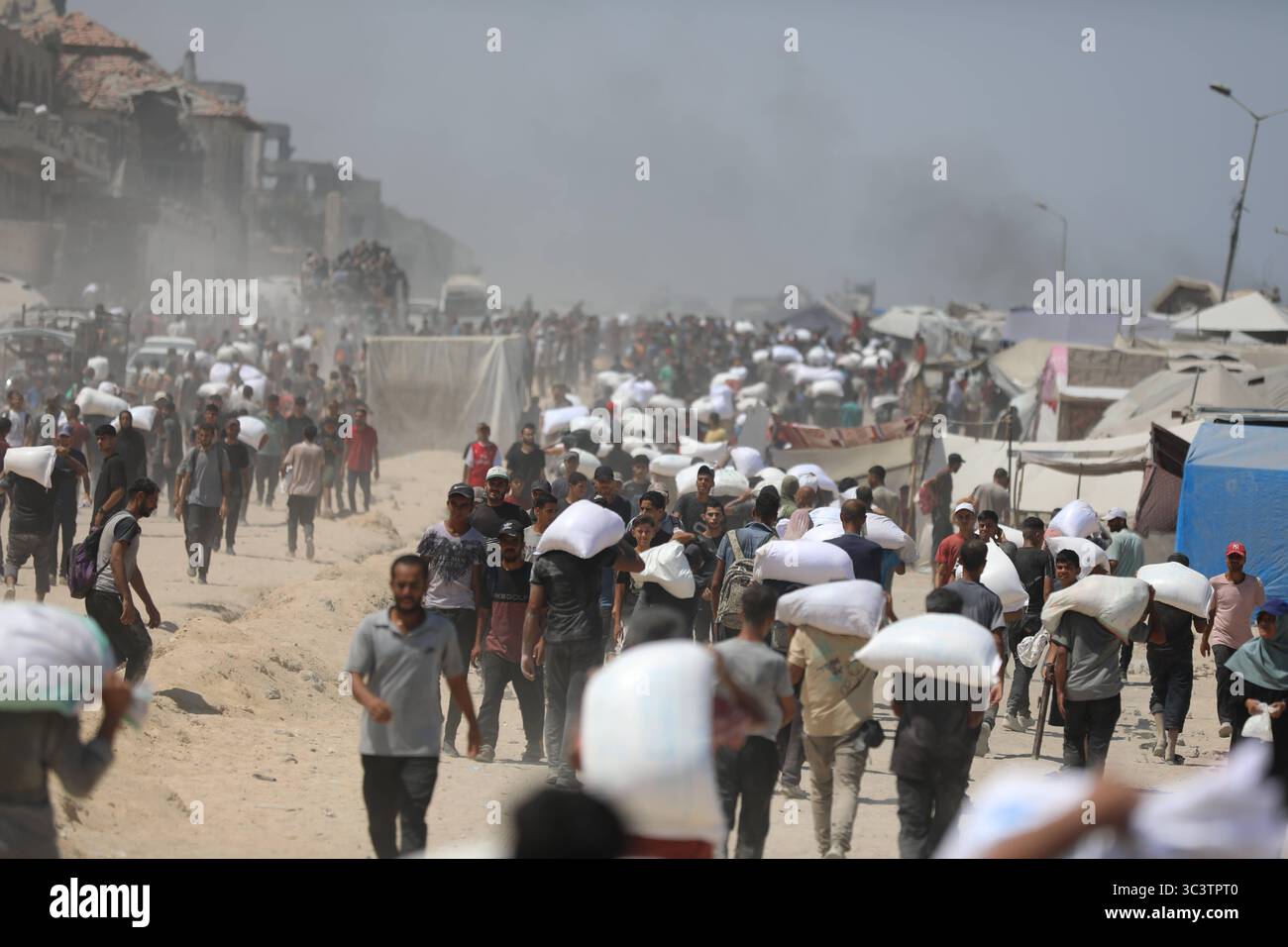People make their way along al-Rashid street in western Jabalia towards ...