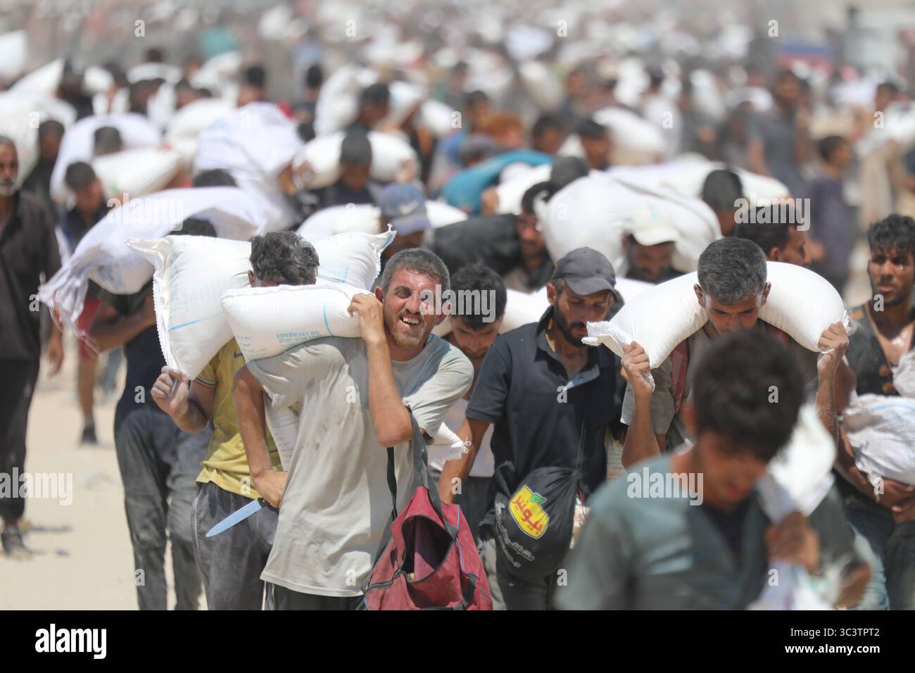 People make their way along al-Rashid street in western Jabalia towards ...