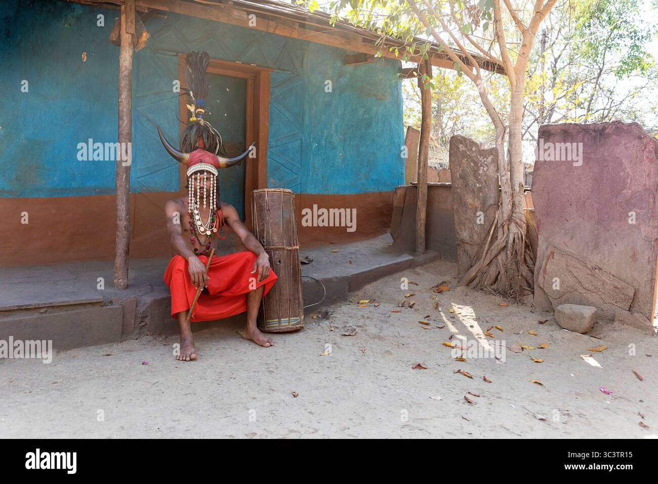 Man in traditional costume from Bison-Horn Maria Tribe sitting infront ...