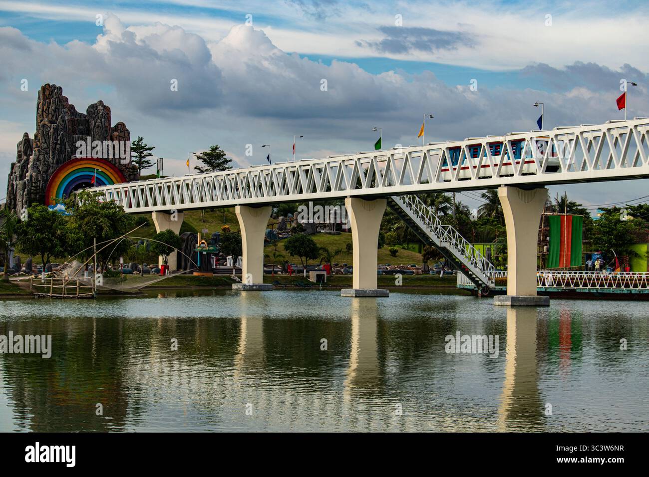 Colorful toy train crossing a mini bridge in amusement park Stock Photo ...