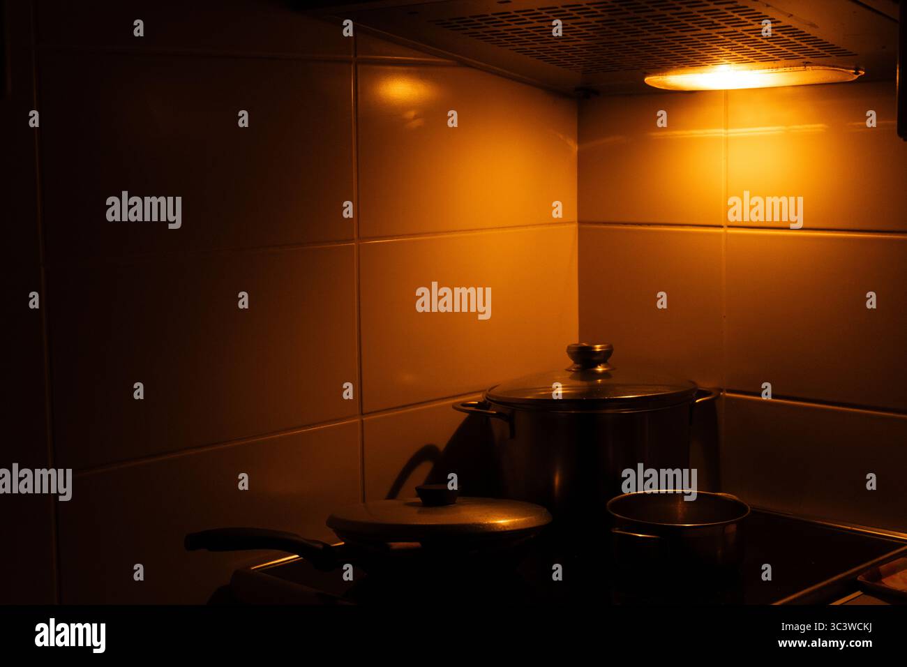 Evening Kitchen Warmth with Soft Light Above Stove Stock Photo - Alamy