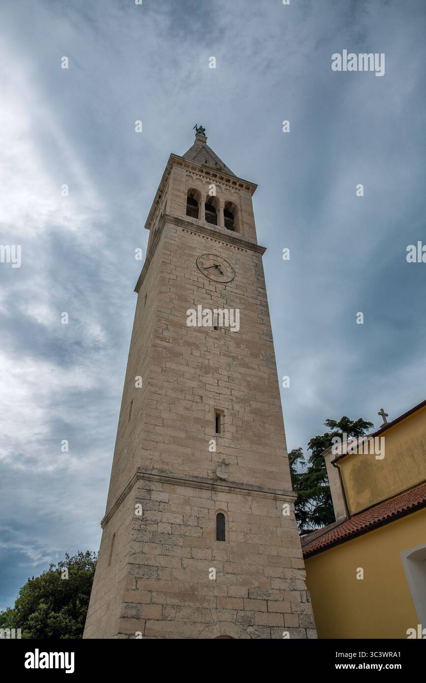Tall medieval Church of St. Pelagia campanile with circular clock and ...