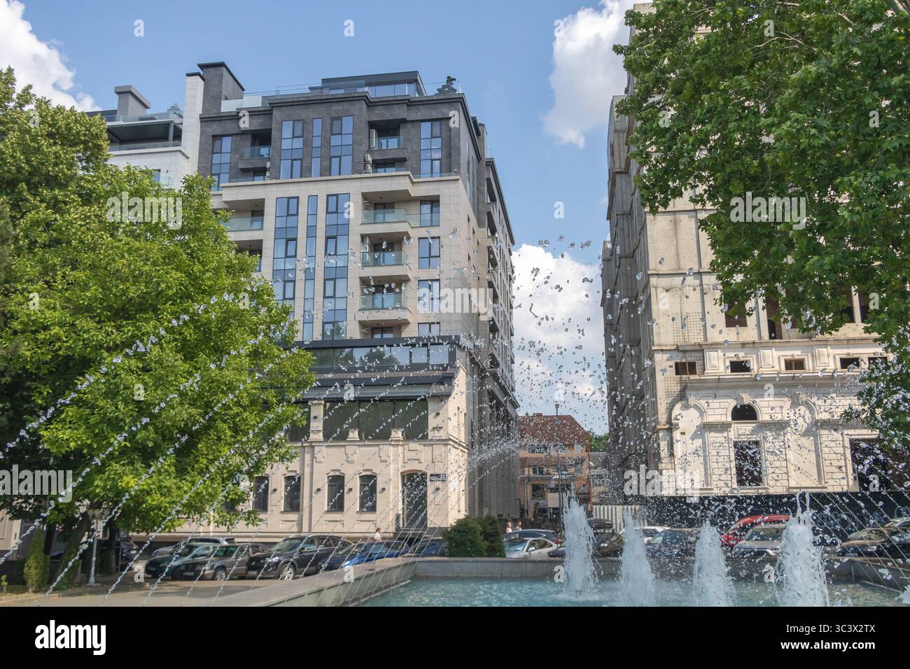 Modern Apartment Building and Classical Architecture Behind Fountain in ...