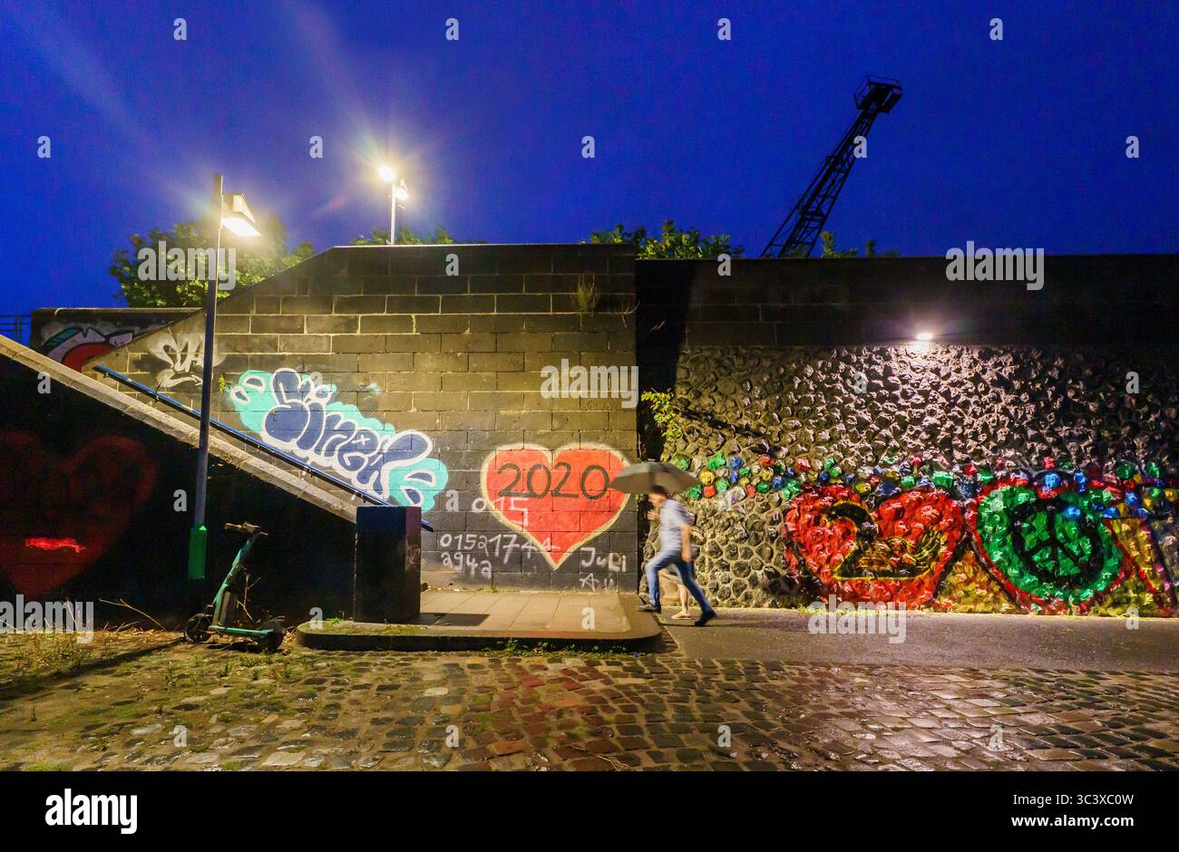 27 July 2025, Hesse, Frankfurt/Main: A man walks past a quay wall with ...