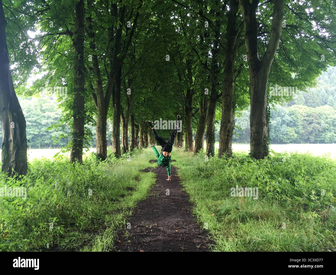 Unrecognisable man doing one hand handstand with legs apart in the ...