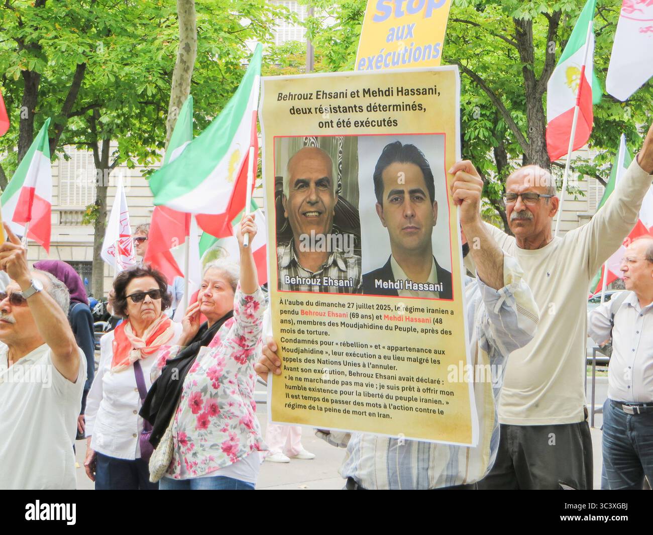 A protester holds a poster bearing the faces of Behrouz Ehsani and ...