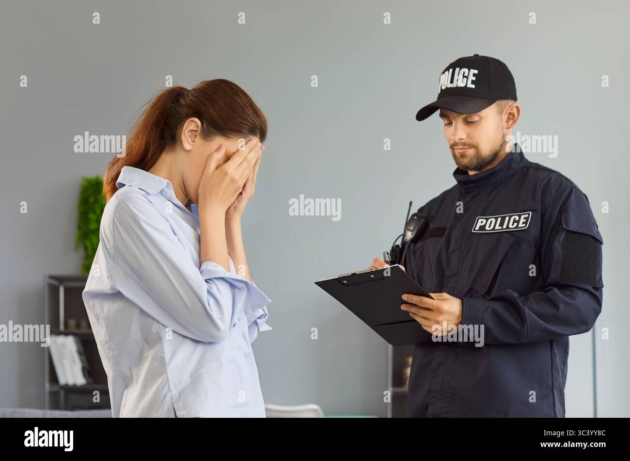 Female victim reports incident to police officer at home Stock Photo ...