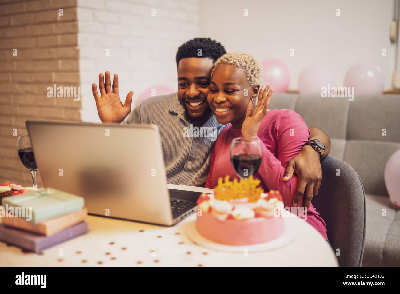 Happy young couple celebrating woman's birthday at home. They are ...
