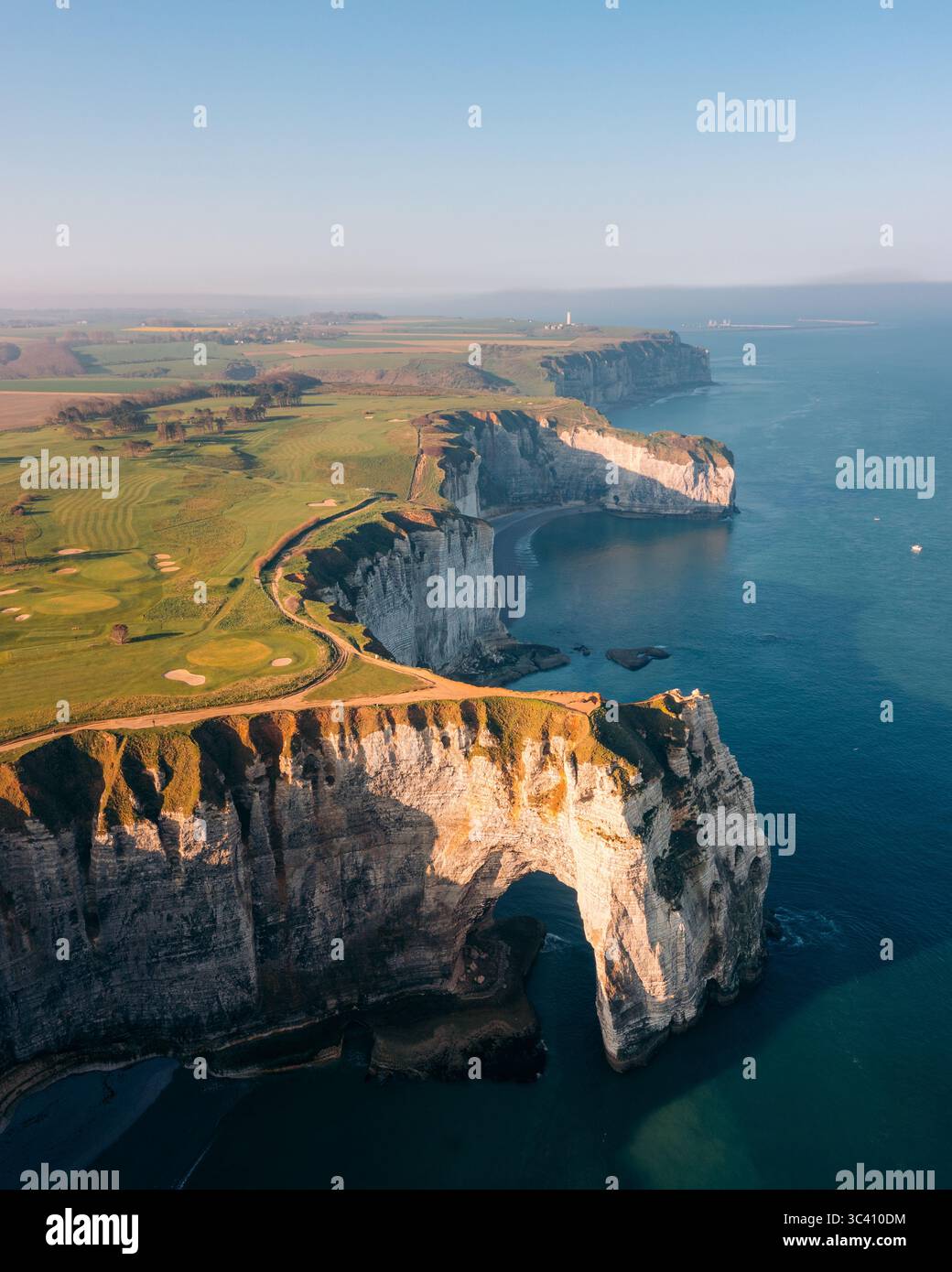 Aerial view of dramatic cliffs meet the deep blue sea at Etretat, where ...