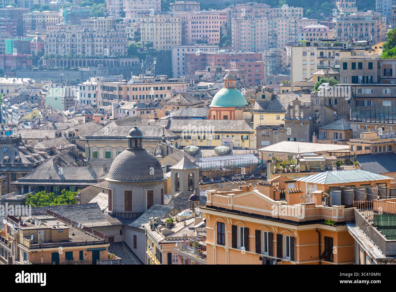 Slate rooftops and domes rise across the layered cityscape of Genoa ...