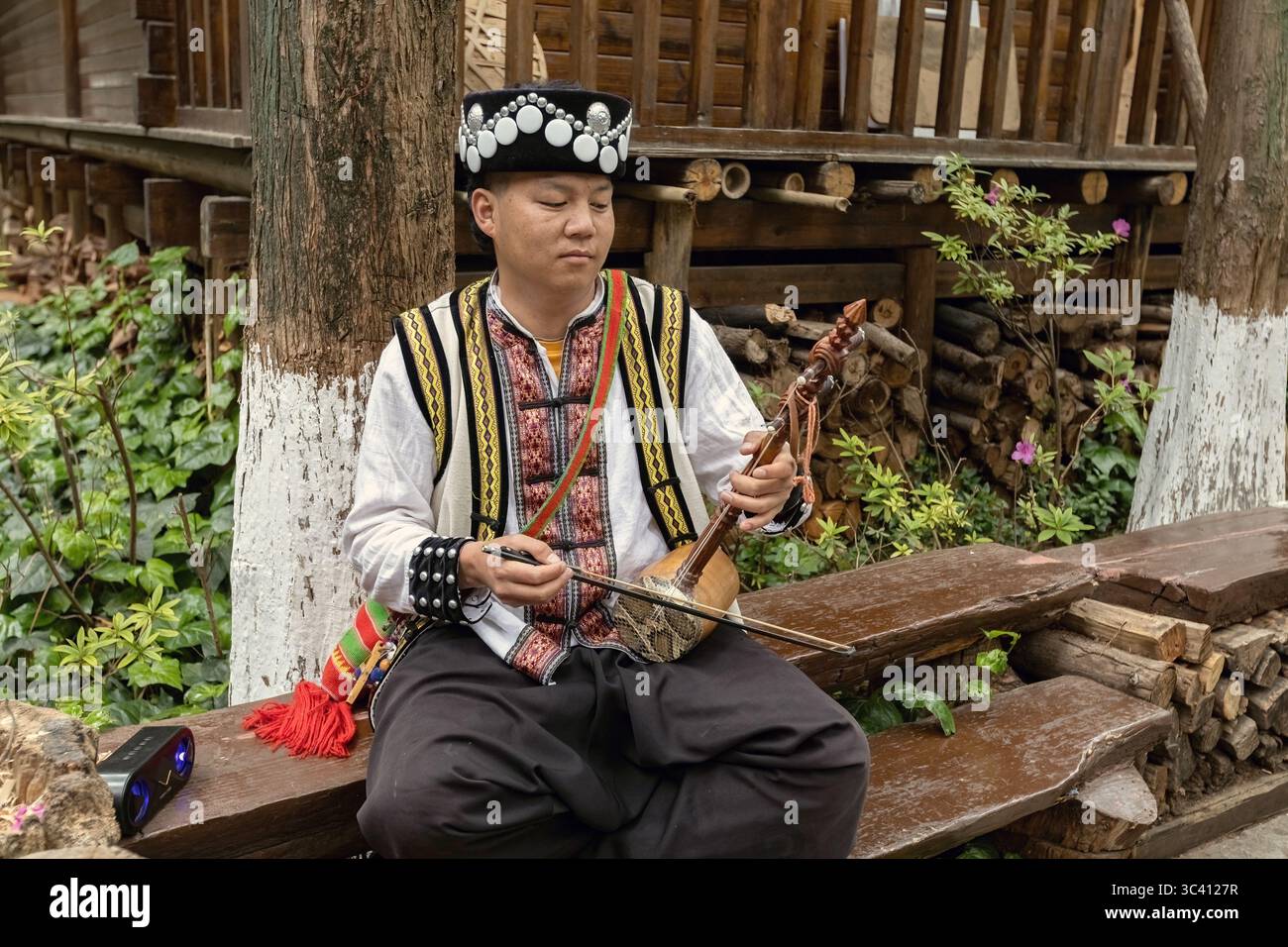 Chinese man playing Touwenxian musical instrument known also as ...