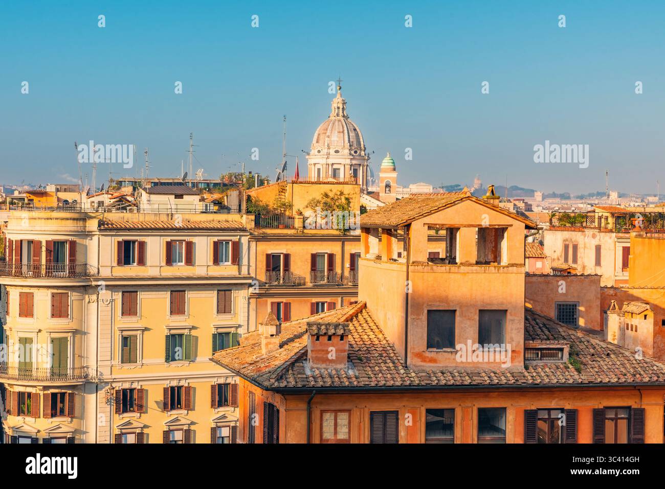 Rooftop view of colorful historic buildings and church dome at sunrise ...