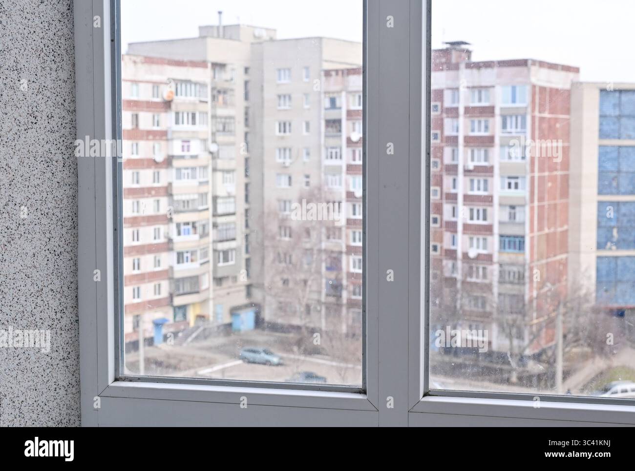 Frosted glass window with plastic frame inside apartment. Blurred city ...