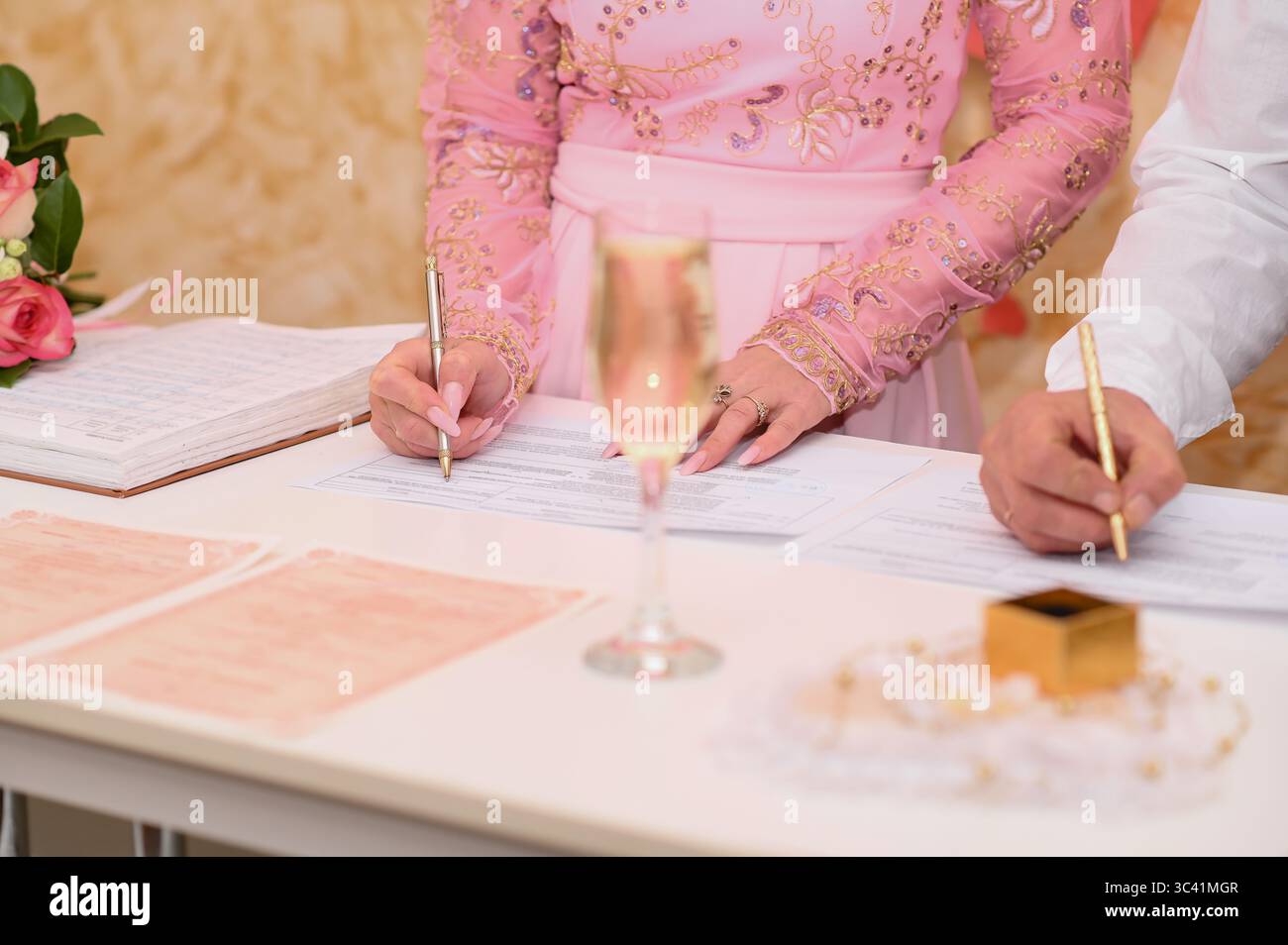 Groom and bride sign marriage documents at registry office, by official ...