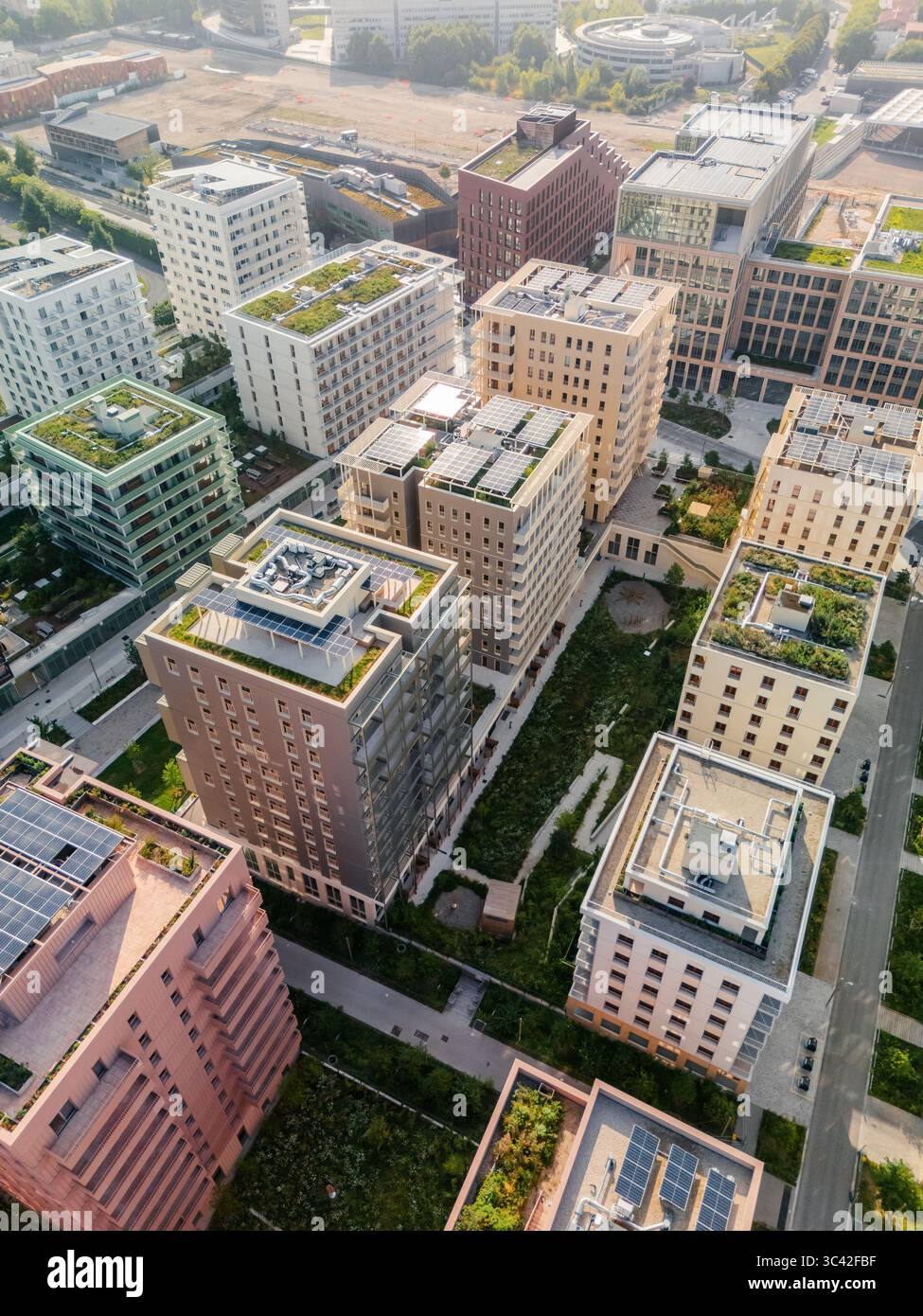 Aerial view of modern buildings with green roofs casting shadows on ...